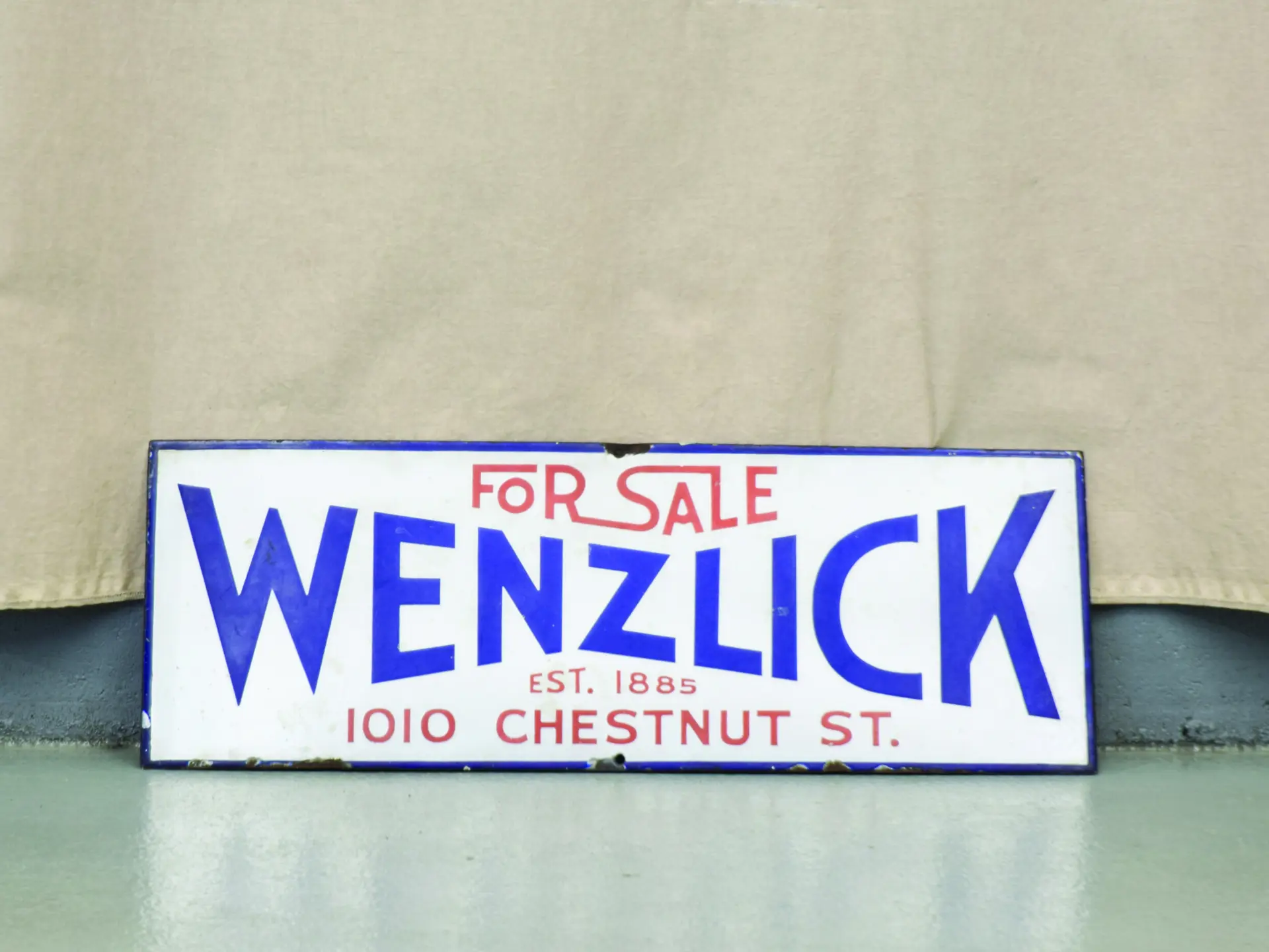 A single-sided, porcelain, Wenzlick sign, 28" x 10". | Auburn Fall 2016 | RM Sotheby's